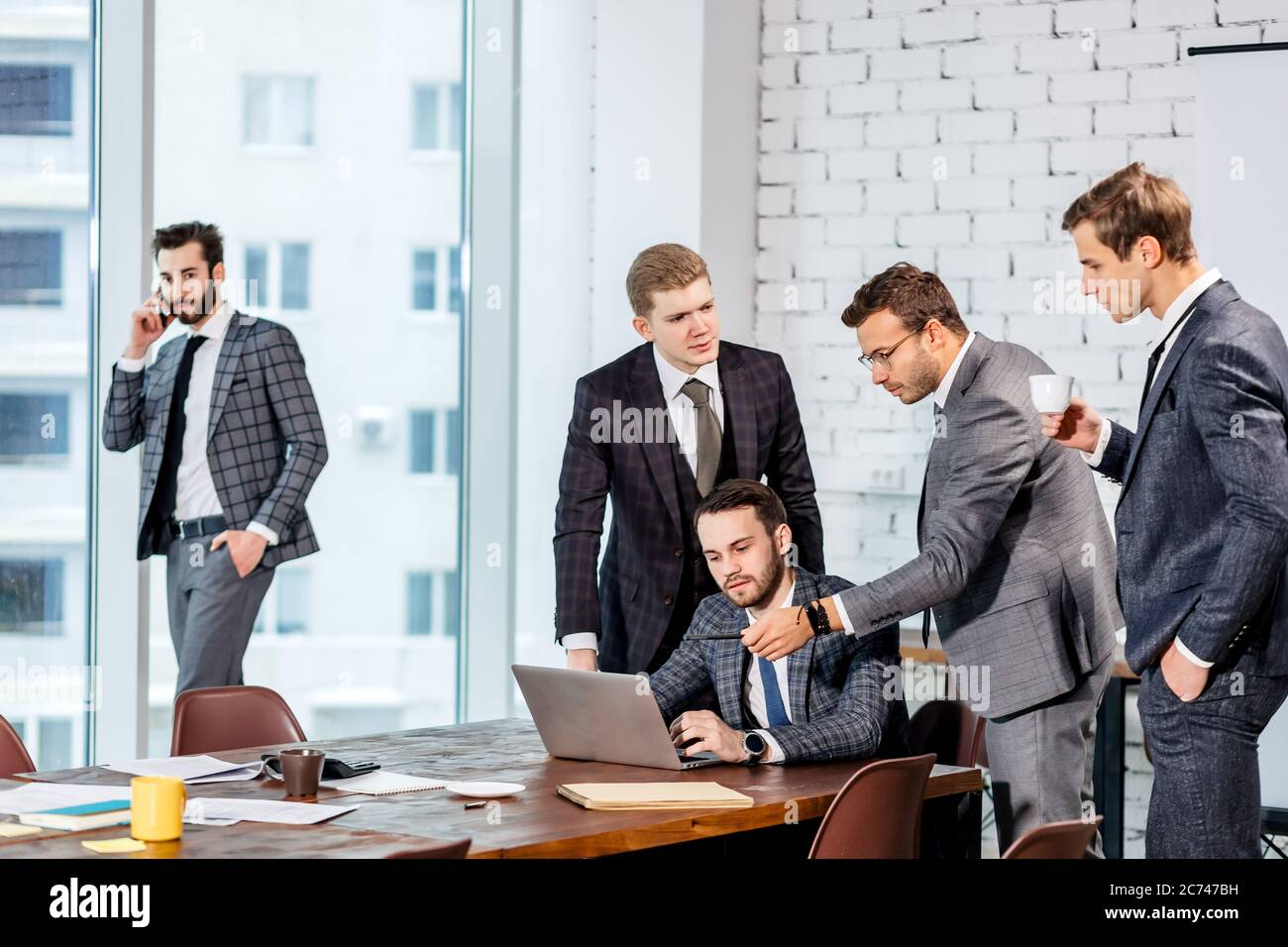 teamwork of young business men gathered in modern office with big ...