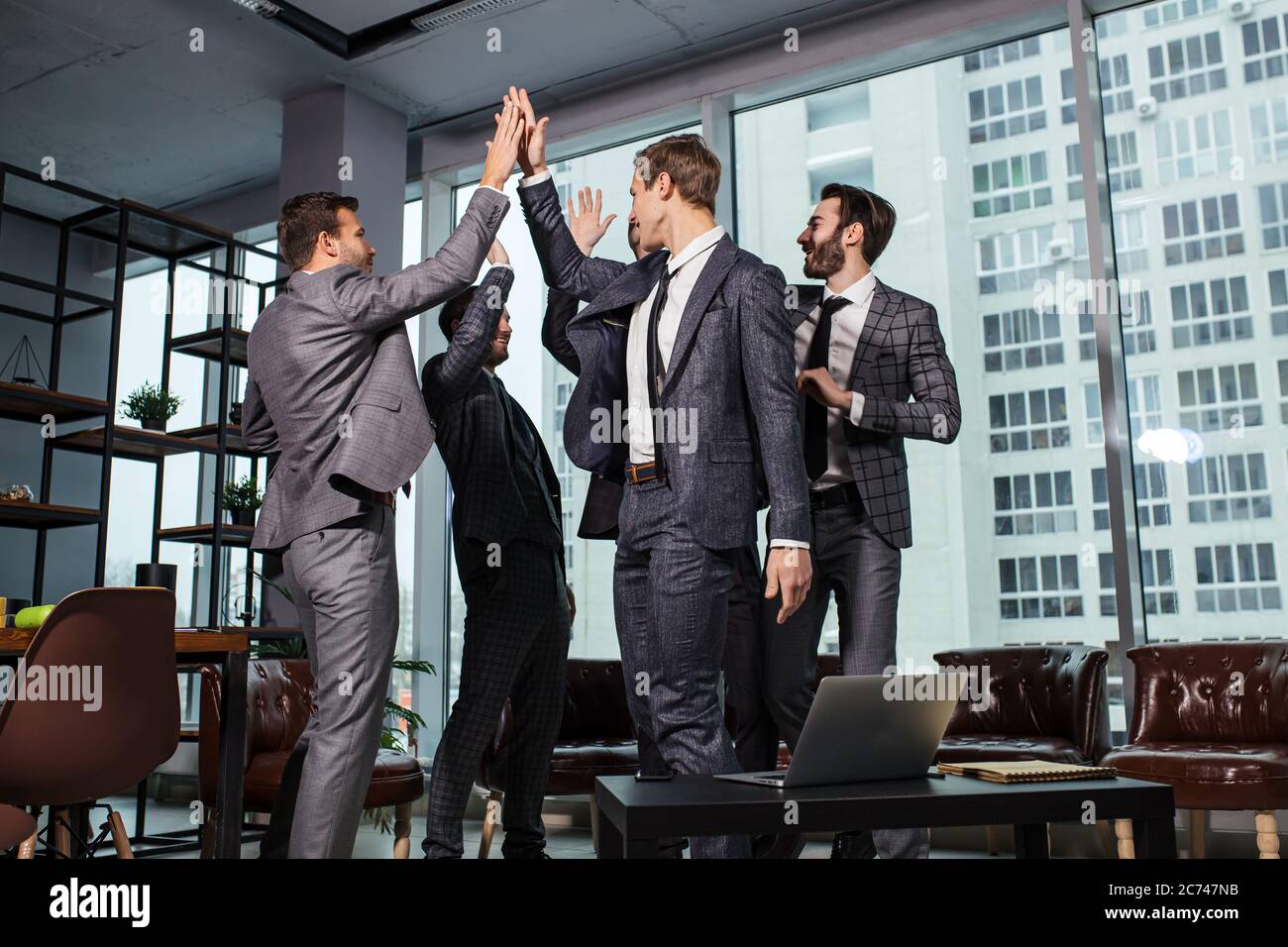 young caucasian business men in suits clapping hands to each other ...