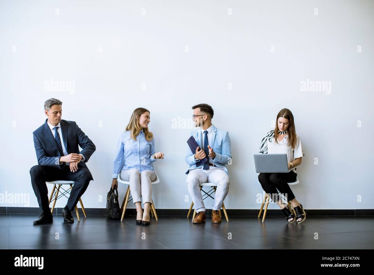 People sitting at chairs in the waiting room before an interview Stock ...