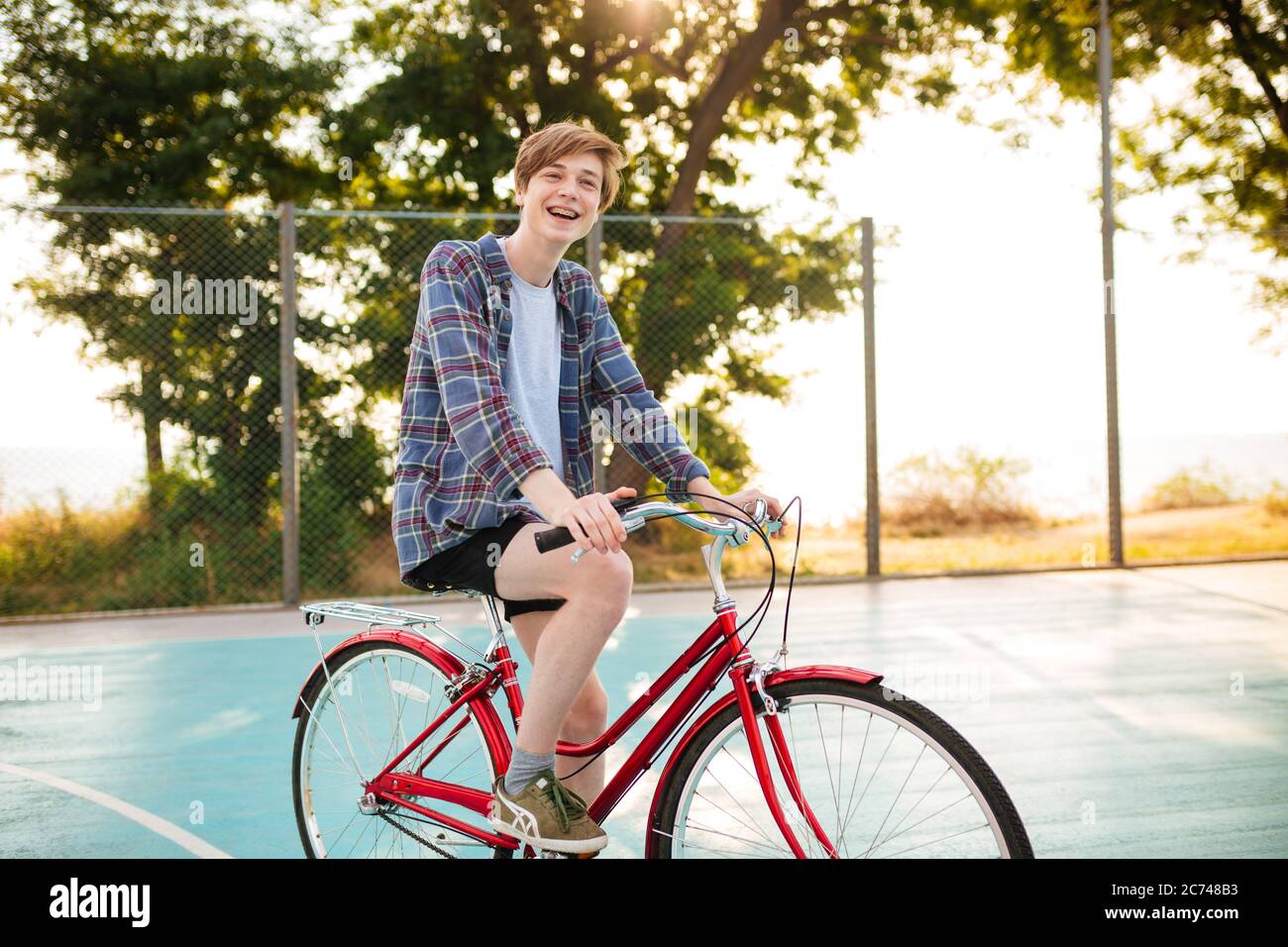 Portrait of cheerful boy with blond hair in shorts and casual shirt ...