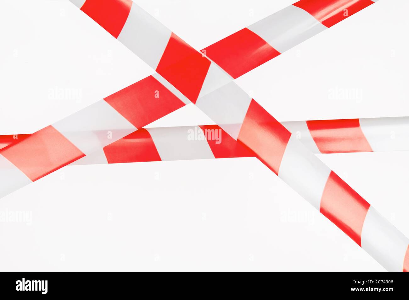 Red and white restrictive tape on a white background. The tape is ...