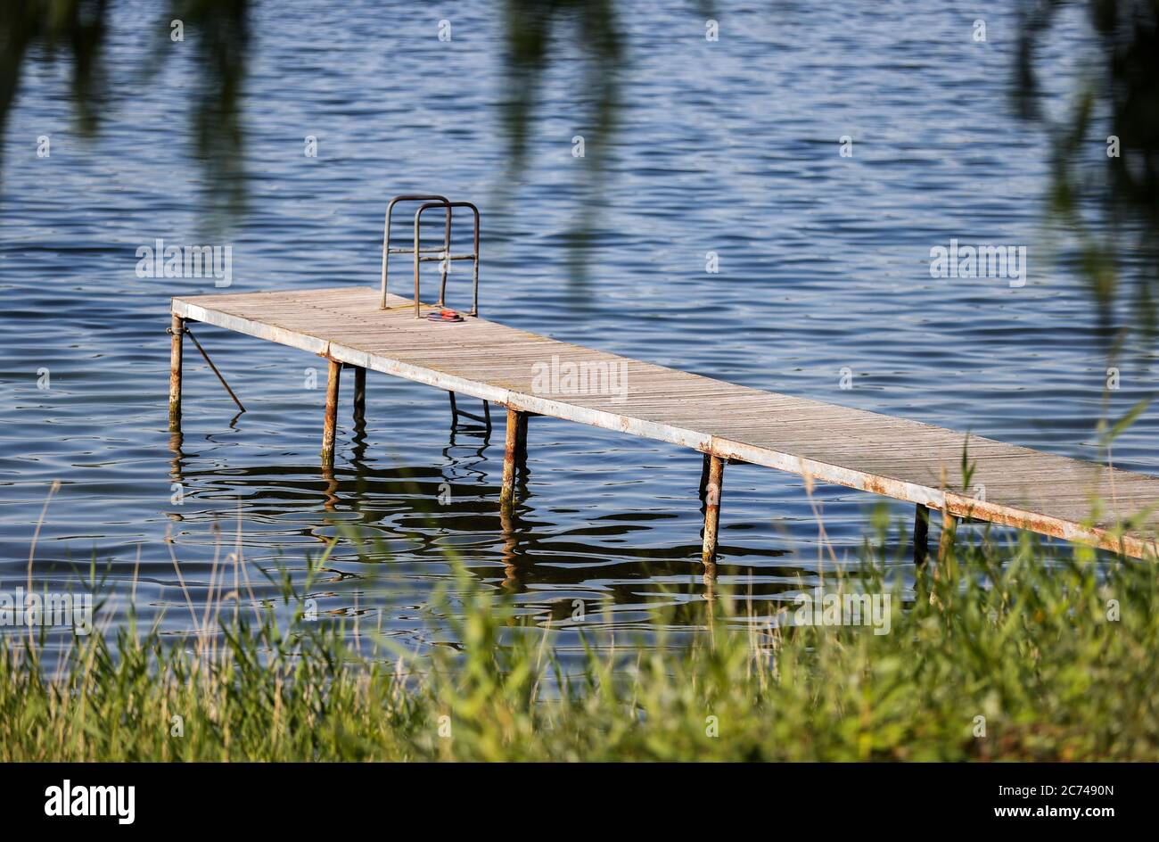 14 July 2020, Saxony-Anhalt, Roßbach: A bathing jetty leads into the ...