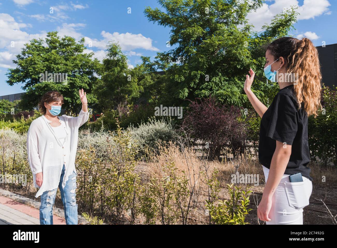 New normal. Social distance. Two people greet each other while ...