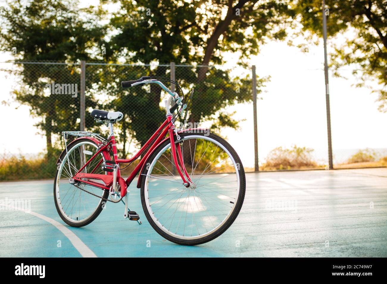Close up photo of red classic bicycle standing on basketball court in ...