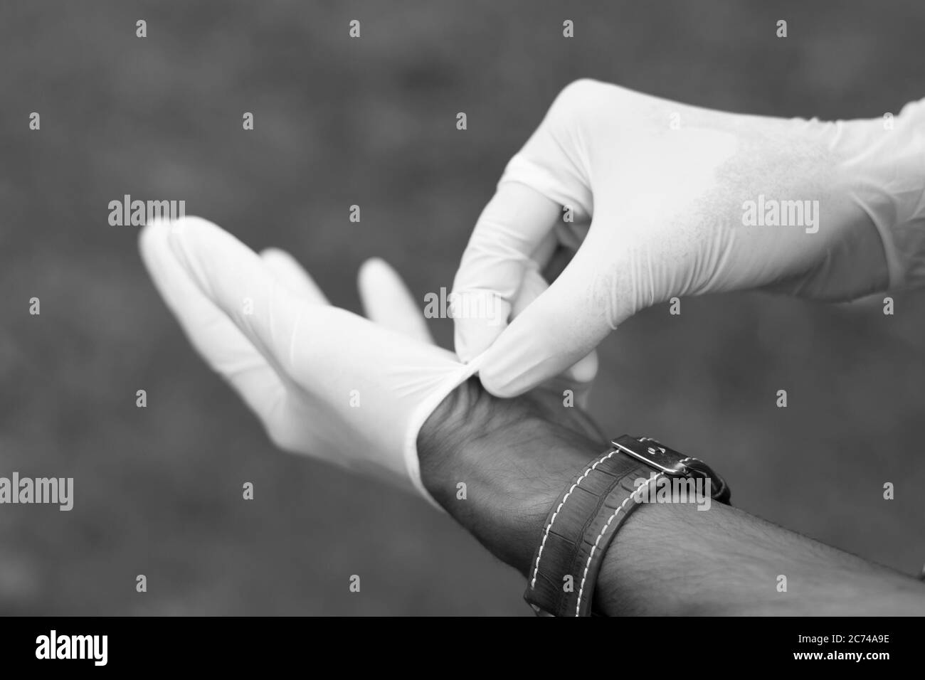 Corona Hand Gloves putting on hand black and white Stock Photo - Alamy