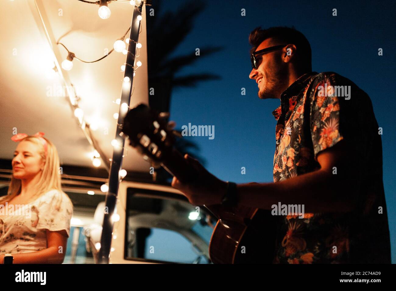 Party men are singing their friends at night near a camper van Stock ...