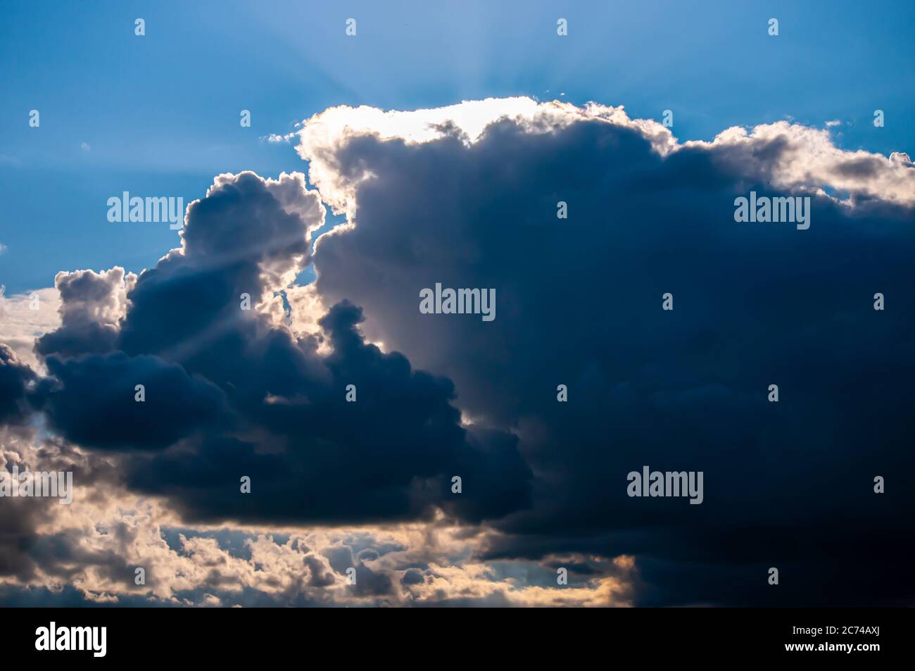Dark clouds with sun behind Stock Photo - Alamy