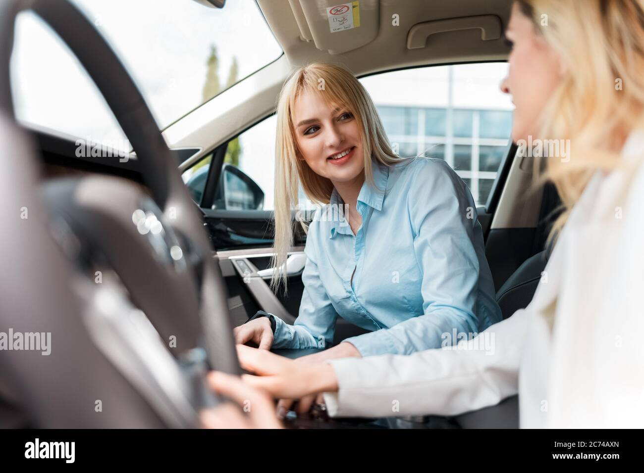 Elegant lady on a test drive with an instructor. Woman practiced to ...
