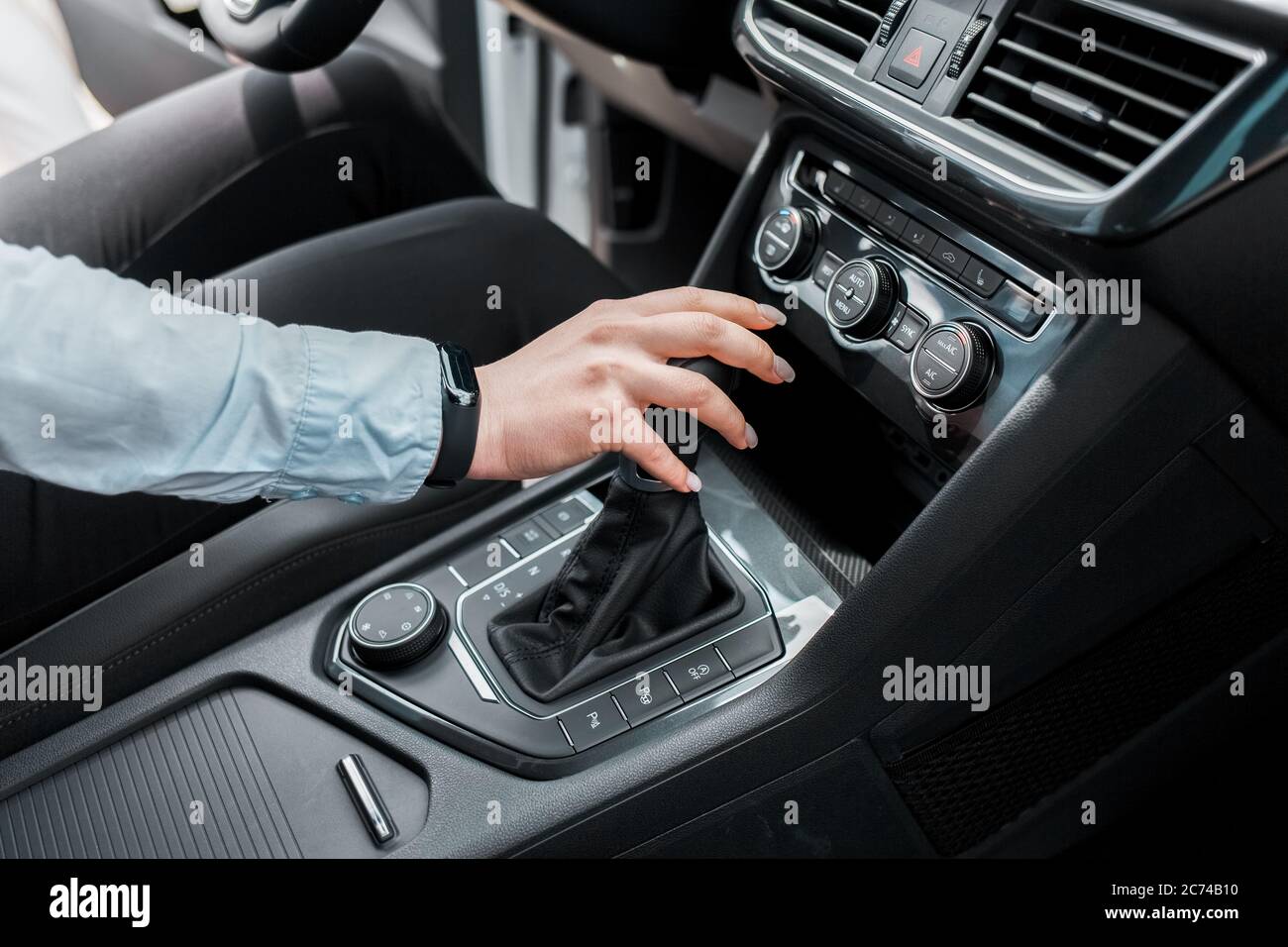Business woman holds her hand on the gear selector automatic ...