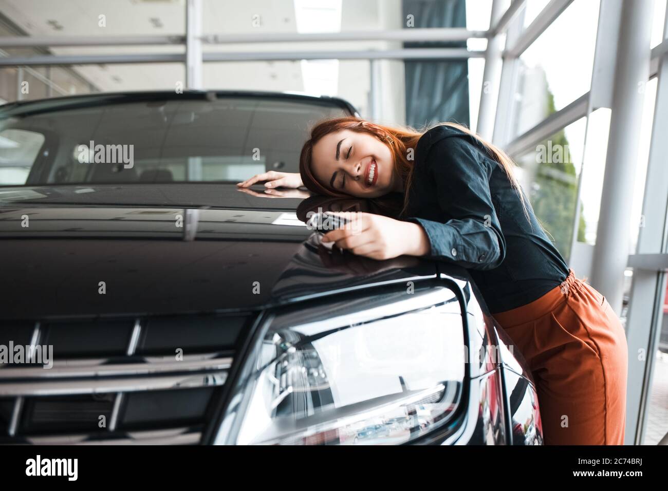 Happy woman hugs her new car Stock Photo - Alamy