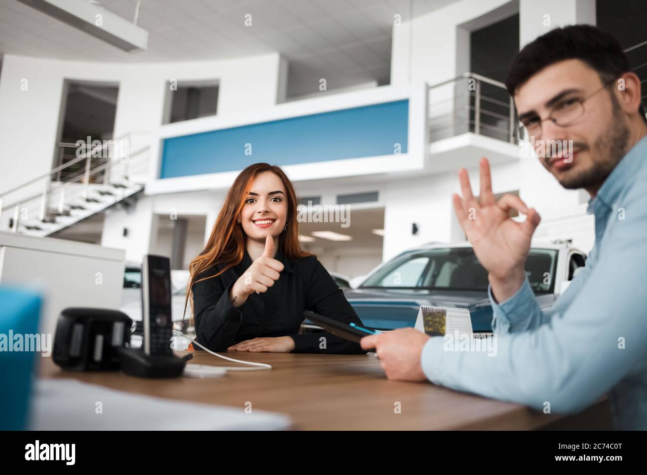 Car showroom client and salesman show ok gestures Stock Photo - Alamy