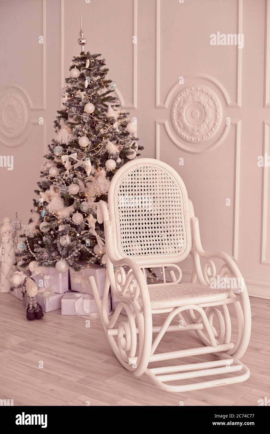 Christmas tree. White armchair. Bright interior Stock Photo - Alamy
