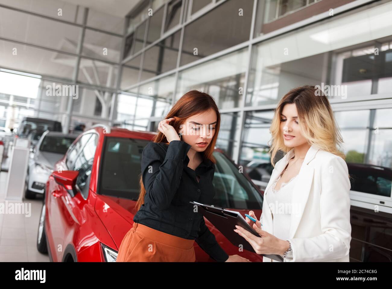 Car dealership manager shows documents for a deal to a client Stock ...