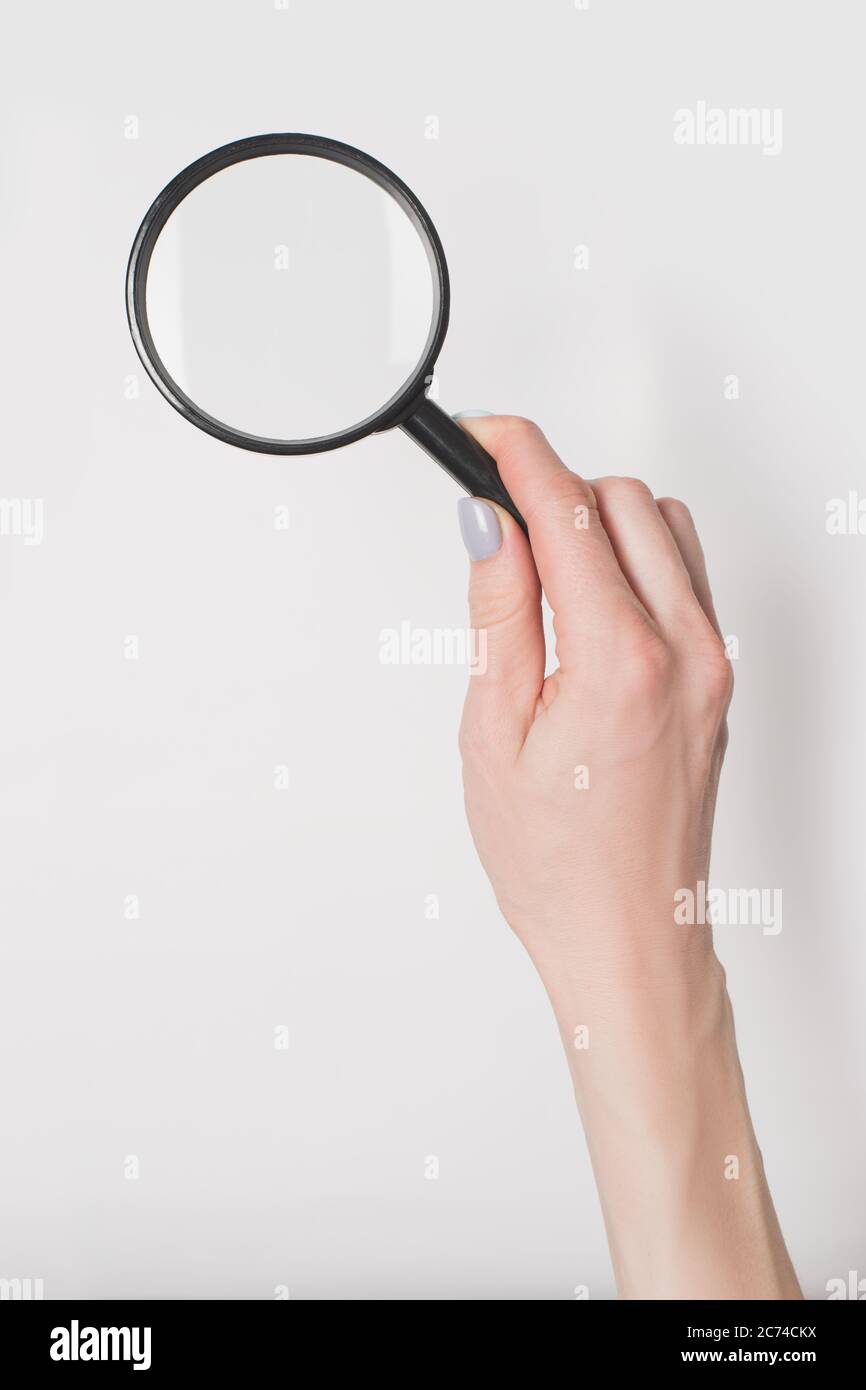 Female hand holding magnifier isolate on light background Stock Photo ...