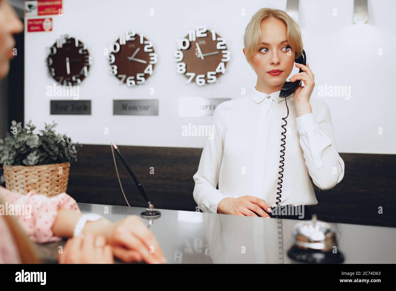 Female receptionist in hotel talking on the phone at work Stock Photo ...