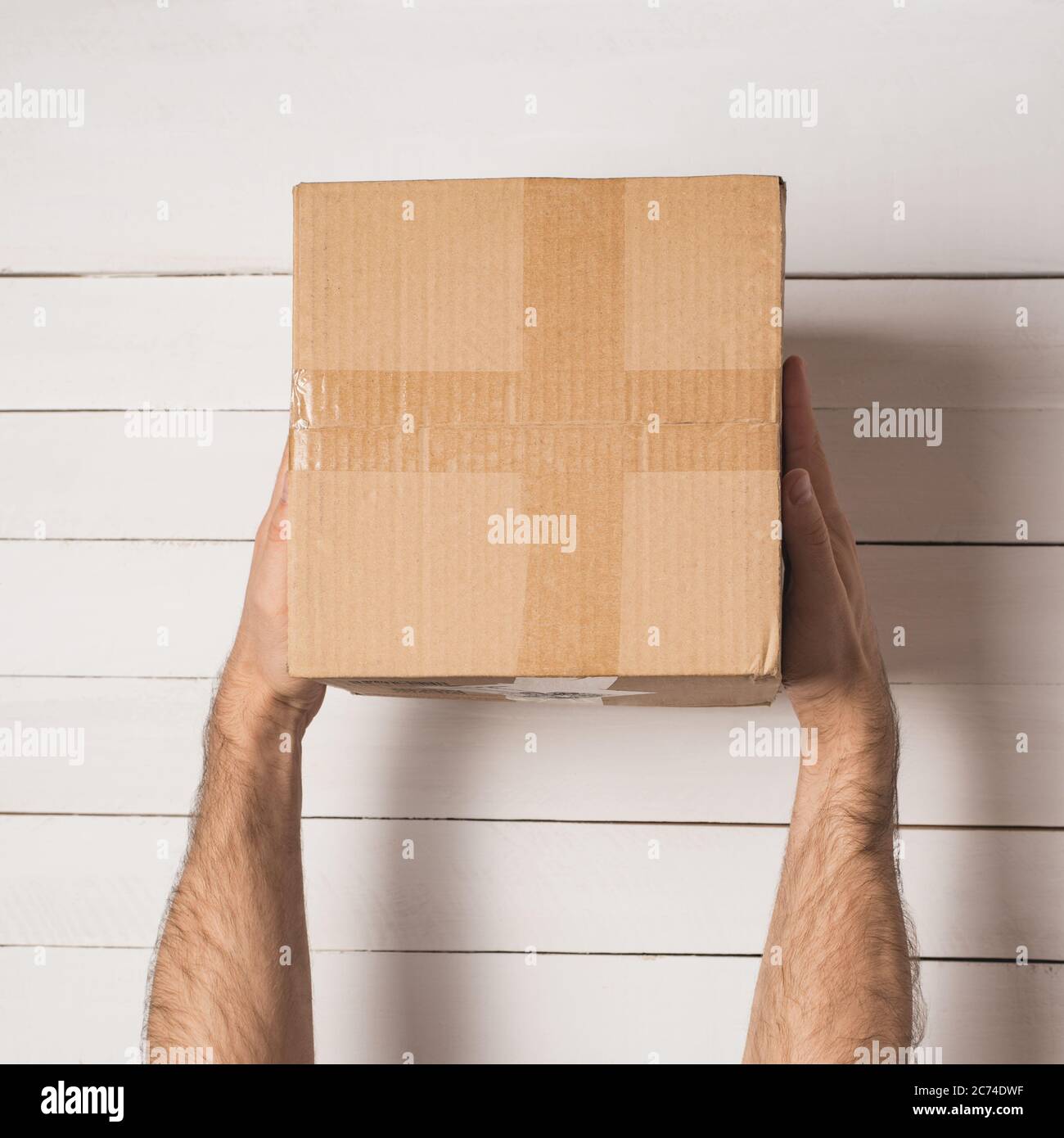 Parcel in male hands. Top view. White table on the background Stock ...