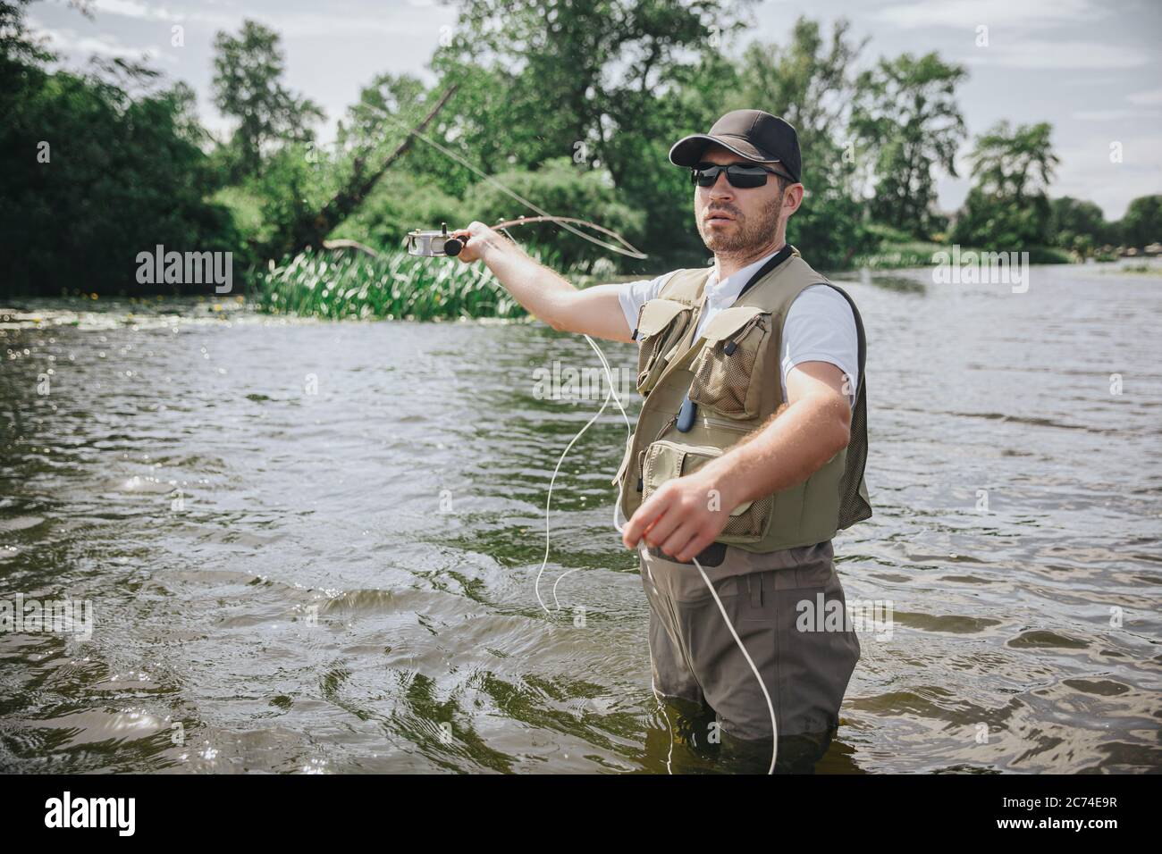 Young fisherman fishing on lake or river. Picture of serious ...