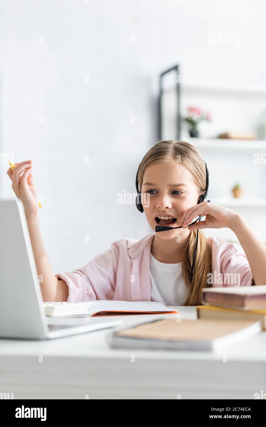 Selective focus of kid using headset during electronic learning at home ...