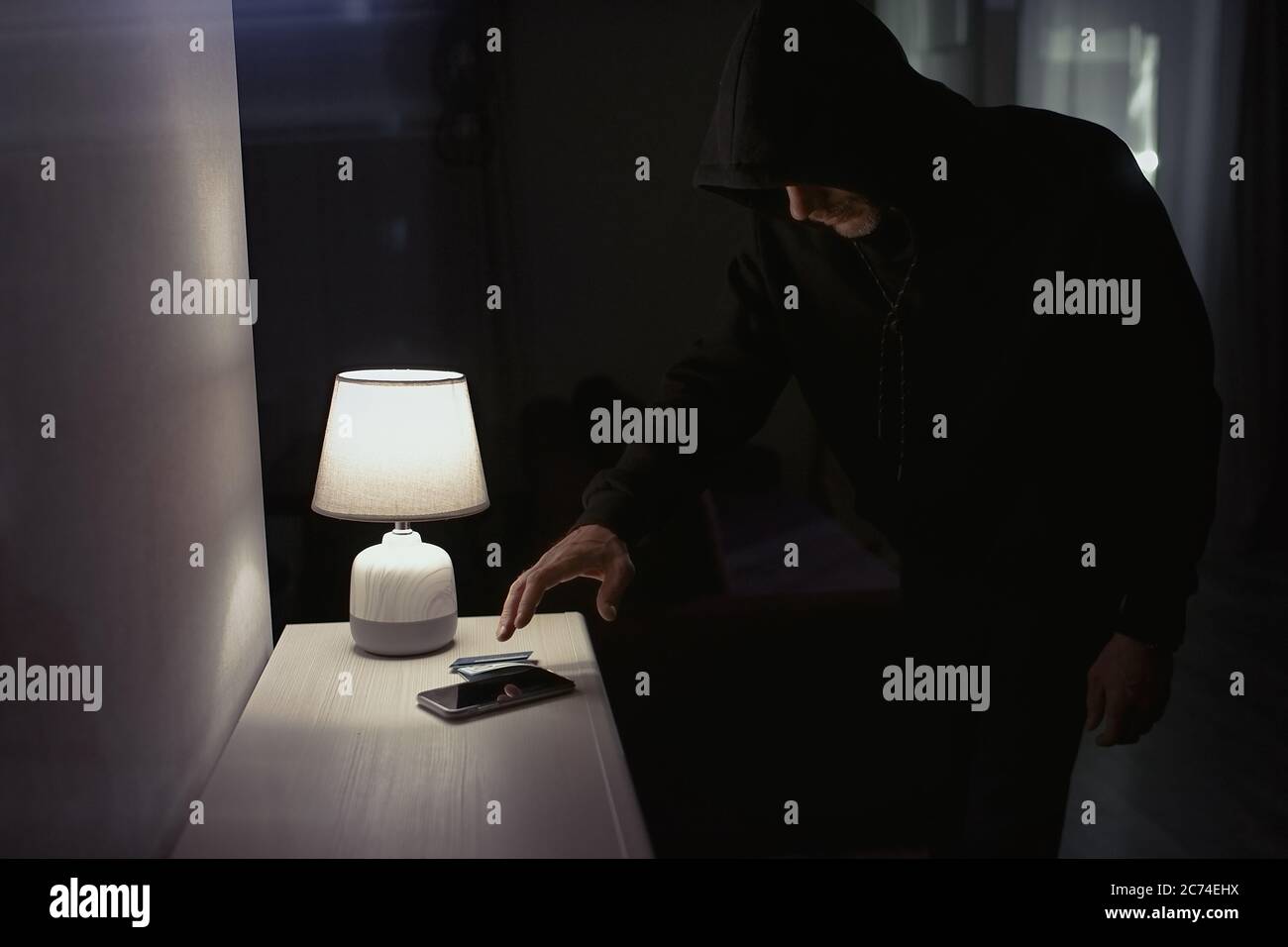 Robber in the hood inside the house at night Stock Photo - Alamy
