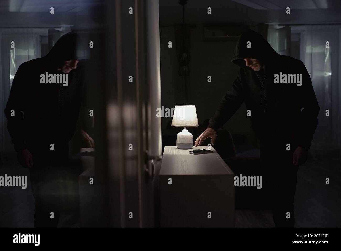 Robber in the hood inside the house at night Stock Photo - Alamy