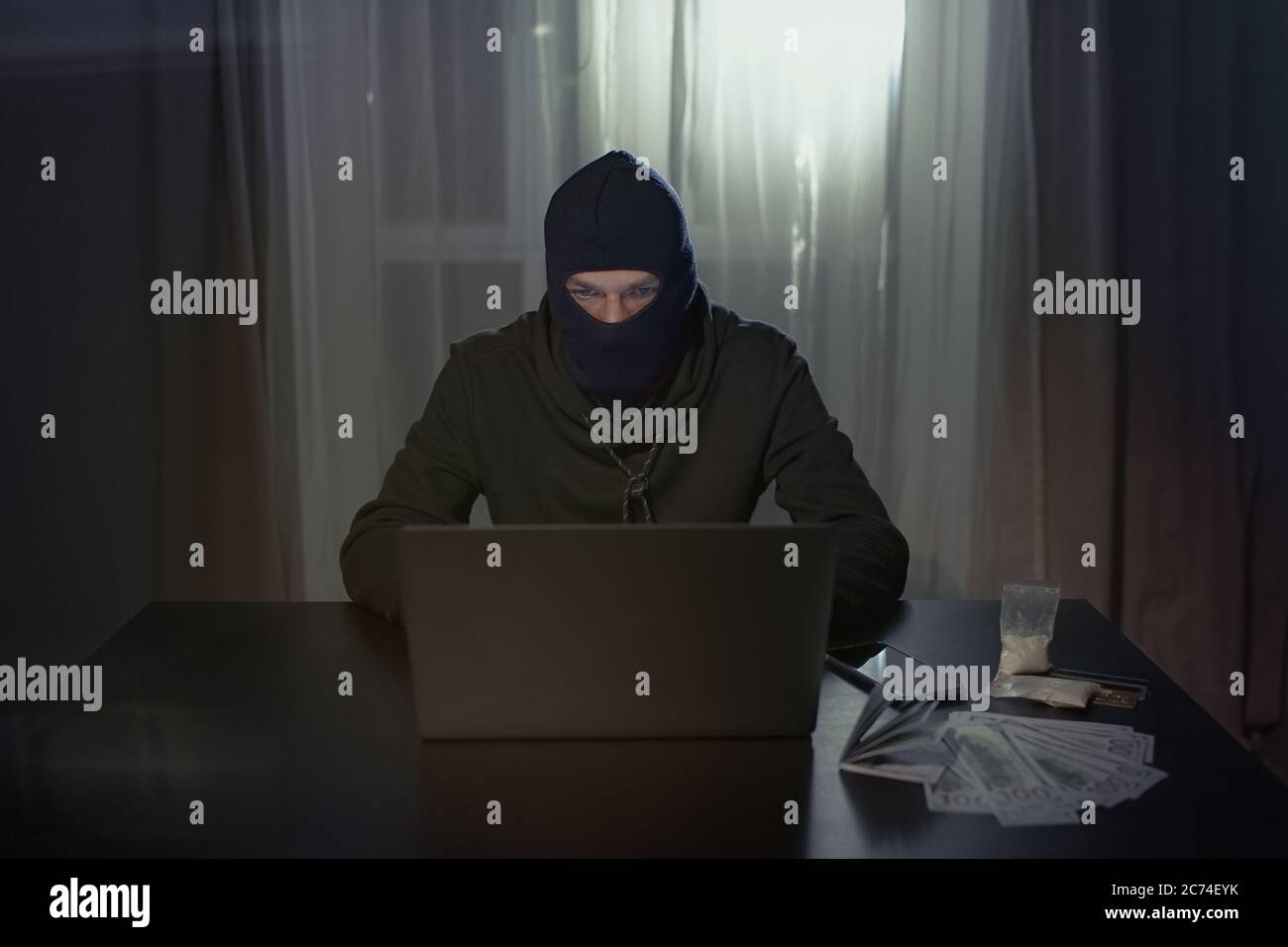 Male Hacker In The Hood In A Dark Room Using Computer Virus Program For Cyber Attack Hackers