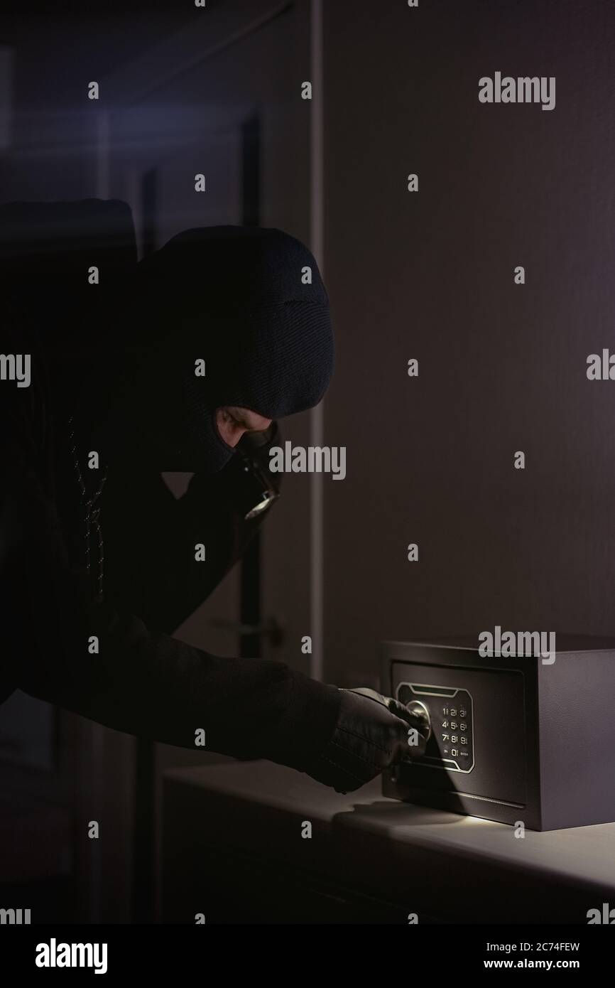 Burglar taking money out of steel safe Stock Photo - Alamy
