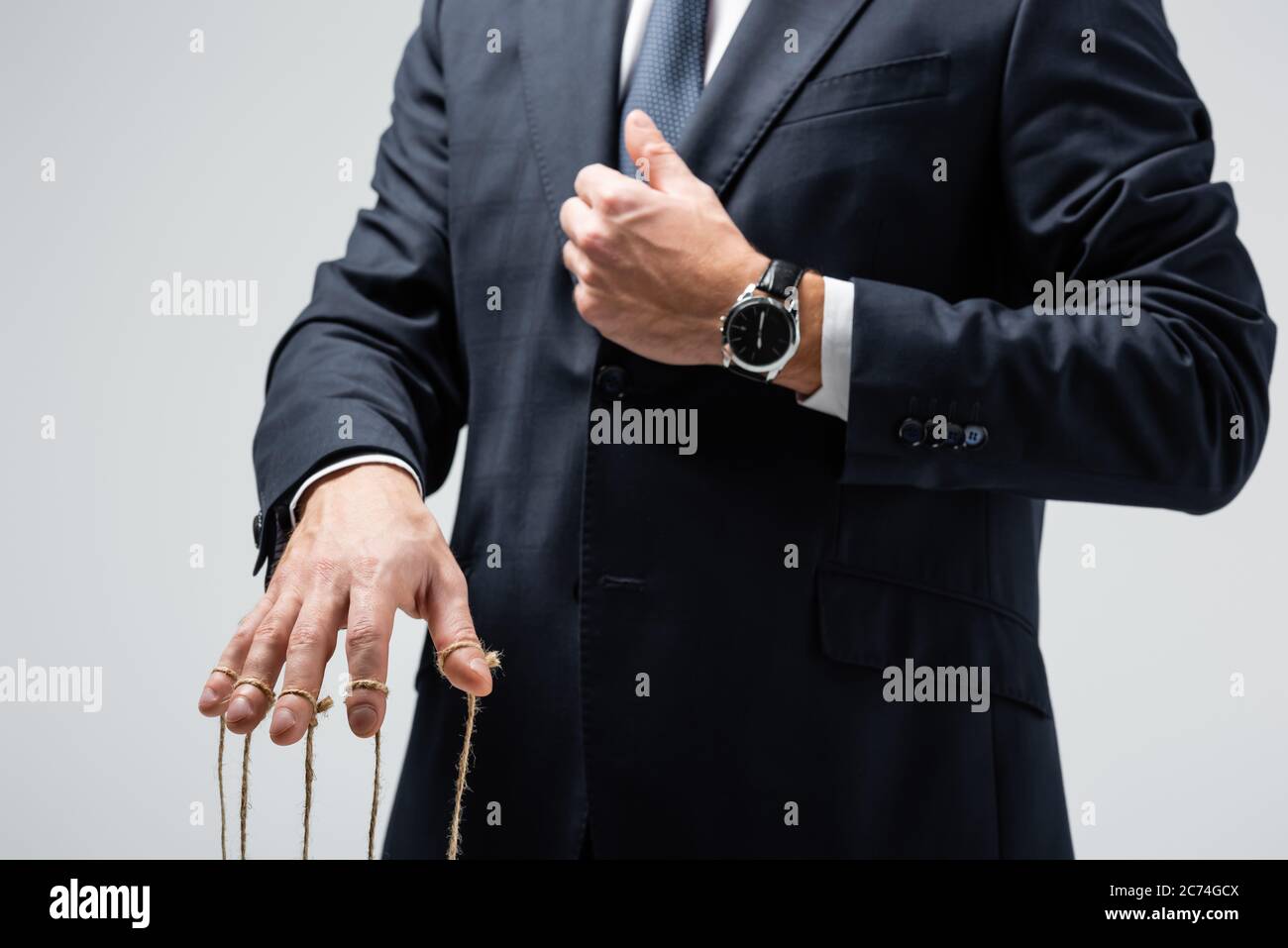 cropped view of puppeteer in suit with strings on fingers isolated on ...