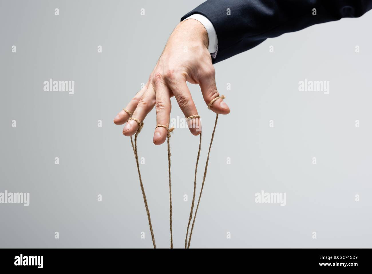 cropped view of puppeteer with strings on fingers isolated on grey ...