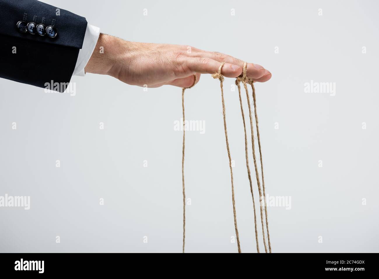 partial view of puppeteer with strings on fingers isolated on grey ...