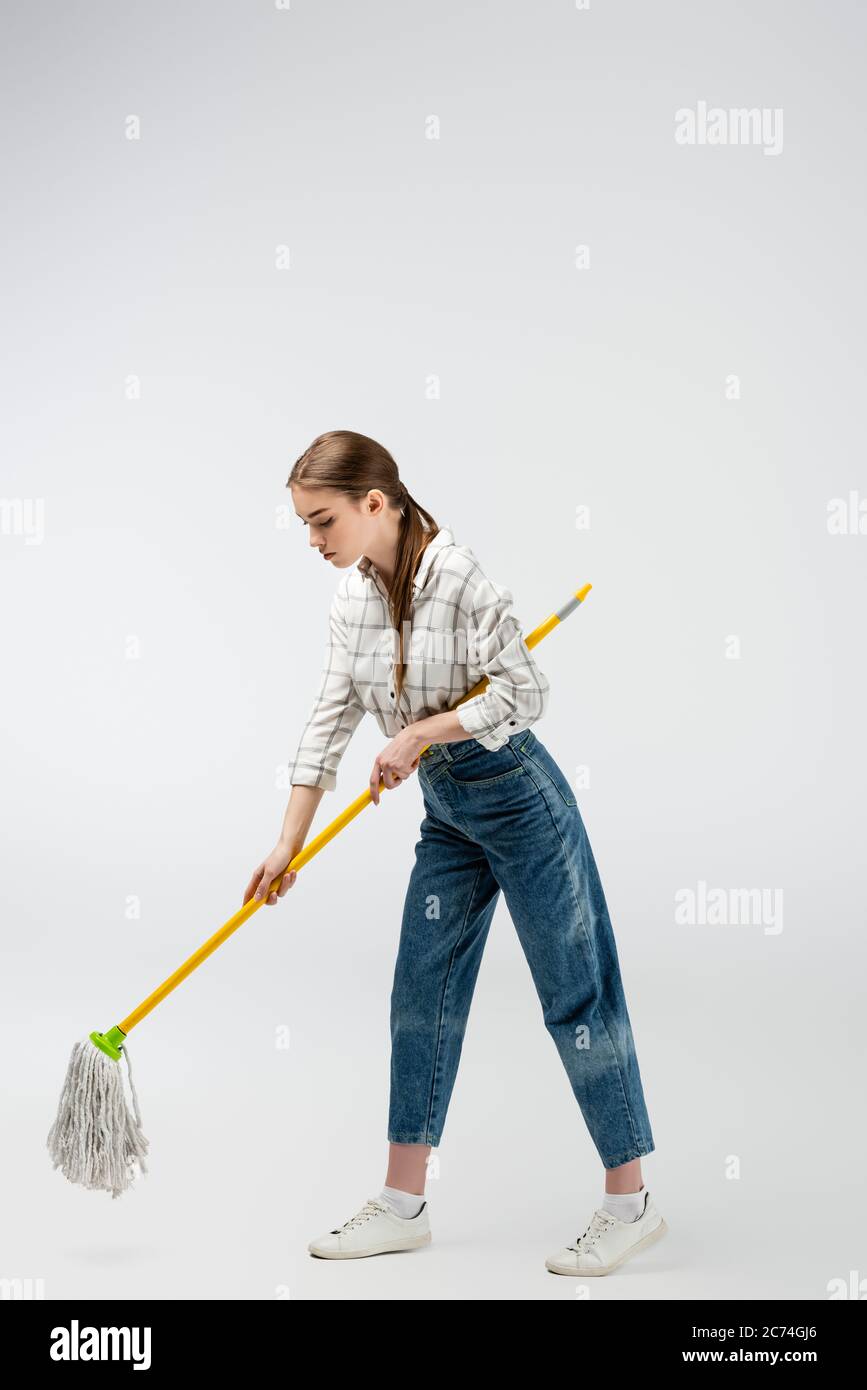 attractive girl posing like puppet with mop and frying pan isolated on ...