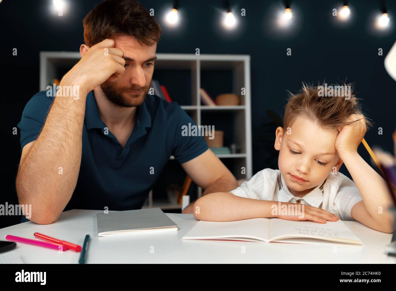 Dad and son doing school homework together Stock Photo - Alamy