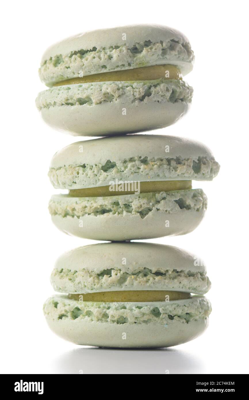 Three mint flavoured macaroons standing on top of each other on white ...