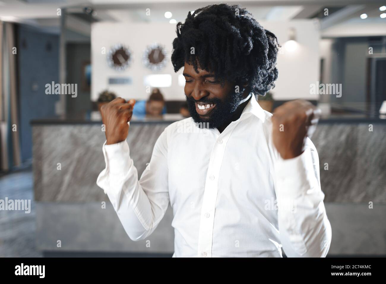 Portrait of a happy african man hotel manager or guest standing against ...