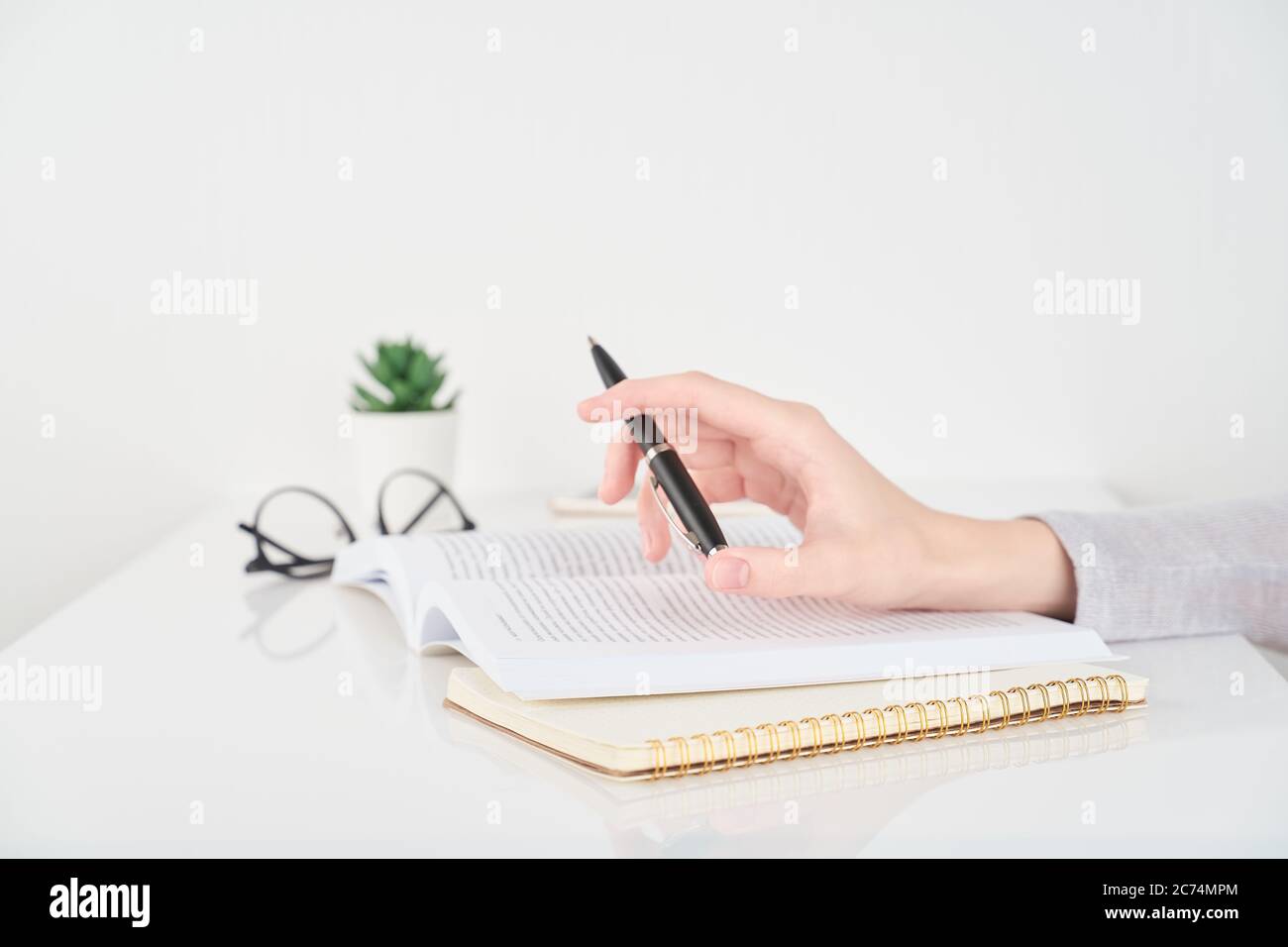 Woman Writing in notebook, Office Work Concept on white wall background ...