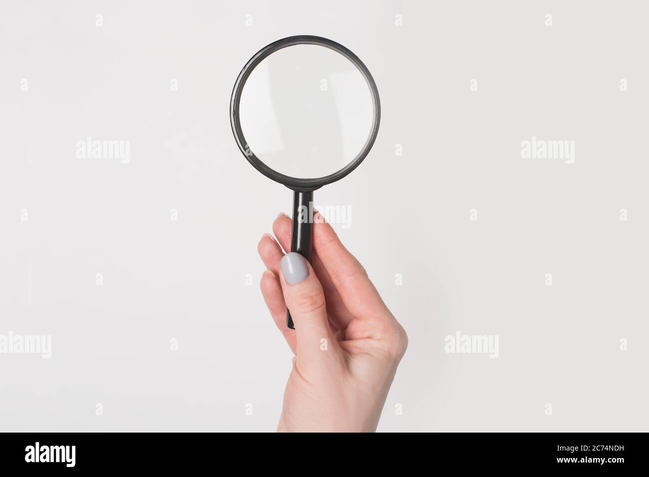 Female hand holding magnifier isolate on light background Stock Photo ...