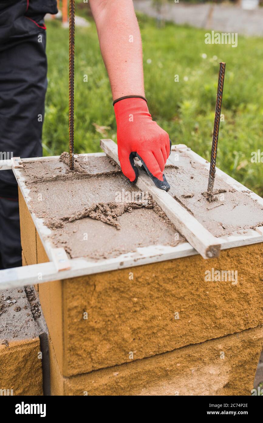 Hard work of a builder - a professional bricklayer skillfully builds ...