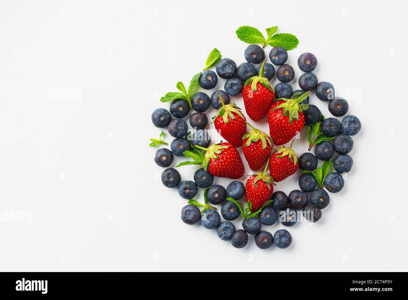 Strawberries and blueberries scattered on white background Stock Photo ...