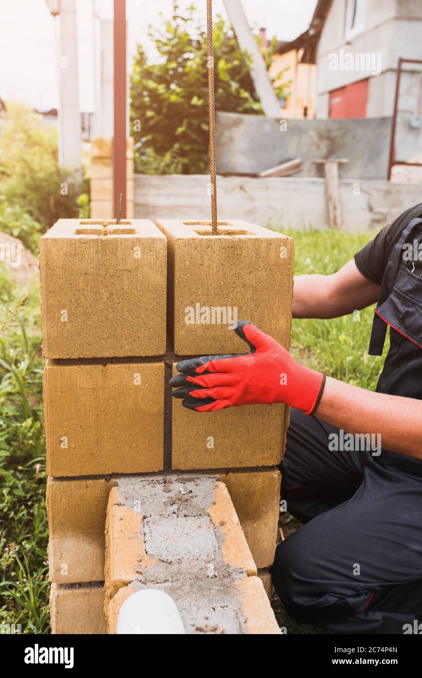 Bricklayer aligns the blocks by level during the construction of a ...