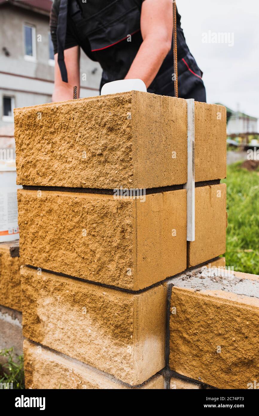 Hard work of a builder - a professional bricklayer skillfully builds ...