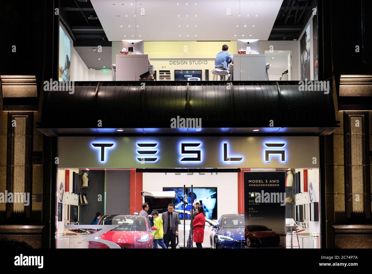 Facade of TESLA store at night. Bright shiny TESLA logo on shop sign ...