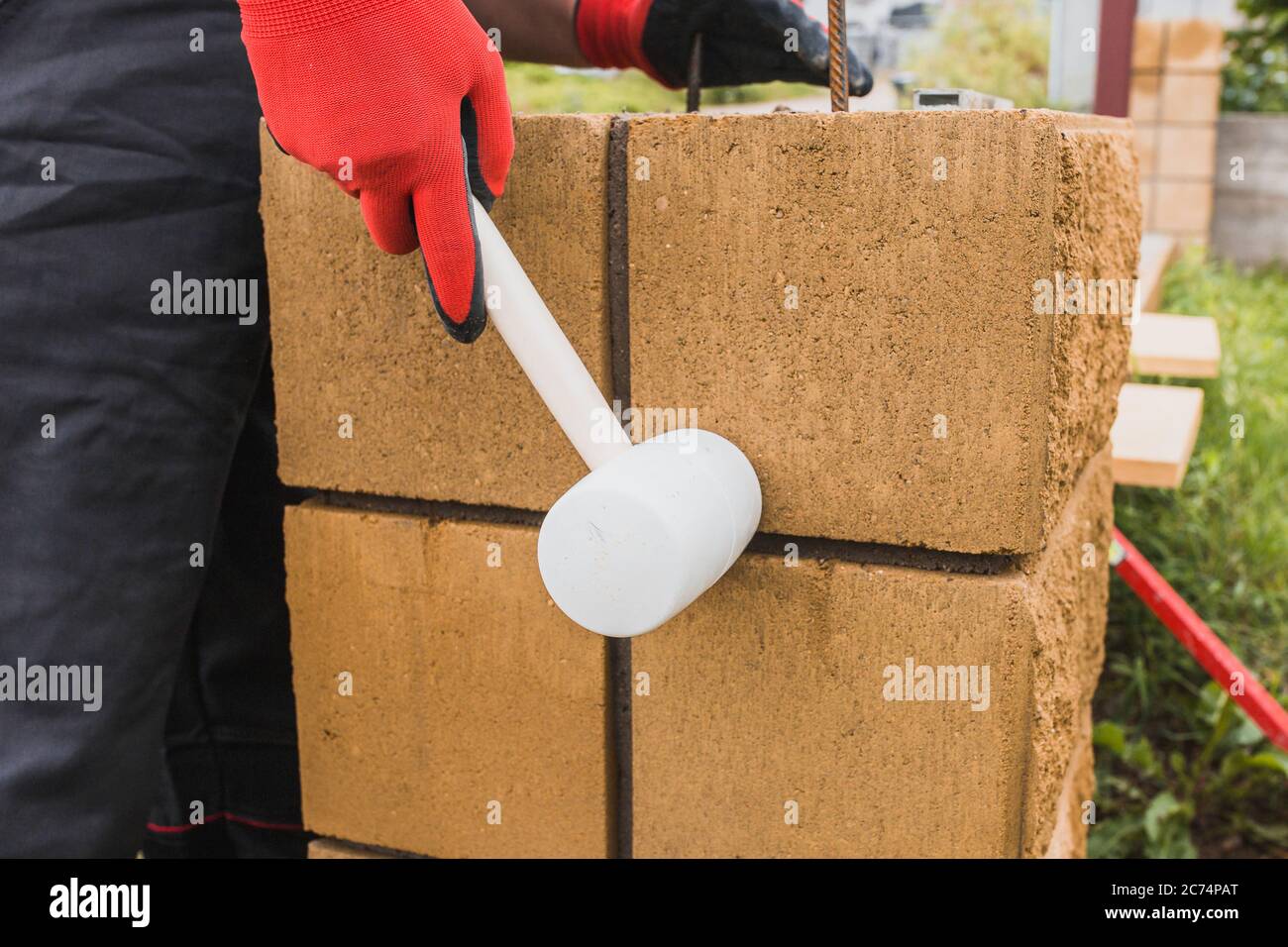 Bricklayer aligns the blocks by level during the construction of a ...