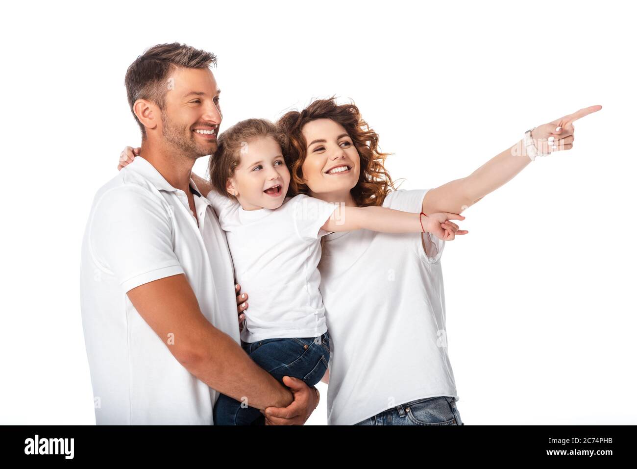 happy mother pointing with finger near cheerful husband holding in arms ...