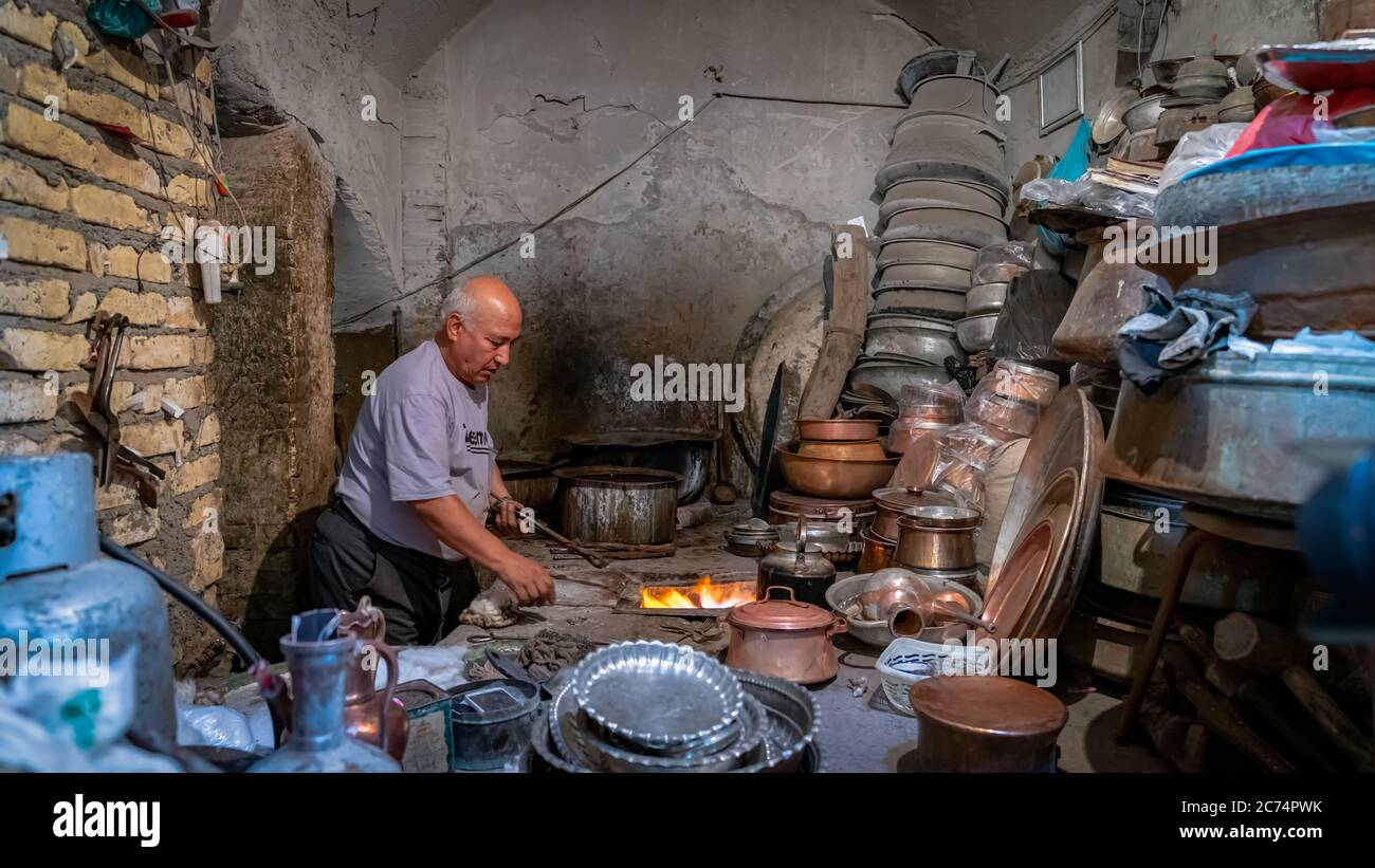 Yazd, Iran - May 2019: Iranian man working with copper cookware in his ...