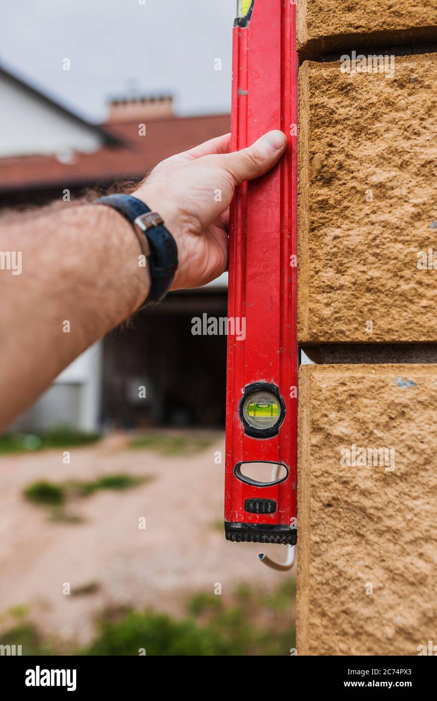 Bricklayer aligns the blocks by level during the construction of a ...