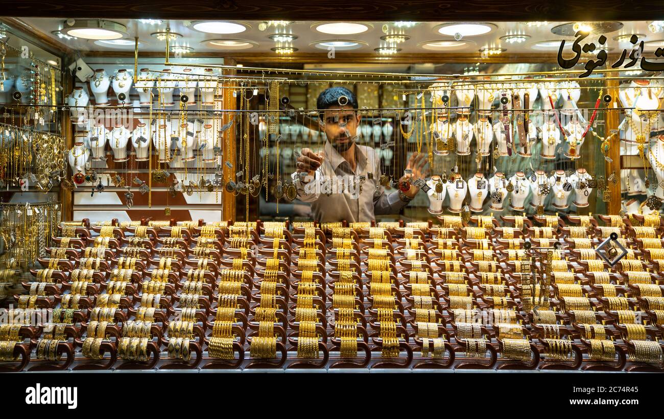 Yazd, Iran - May 2019: Man working inside the window display of gold ...