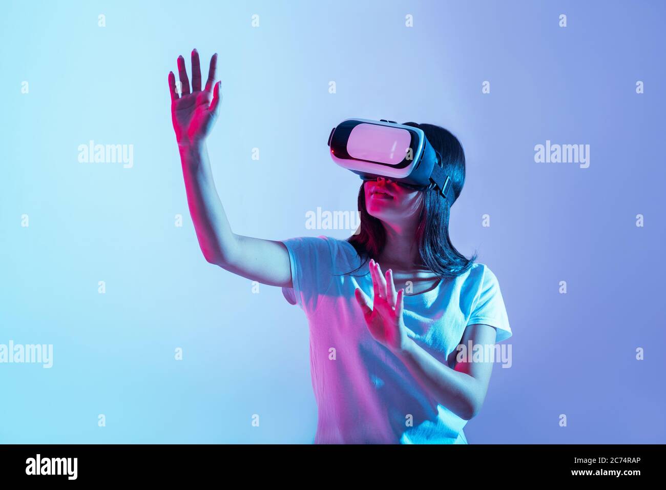 Virtual game of new generation. Girl in glasses examining something and ...