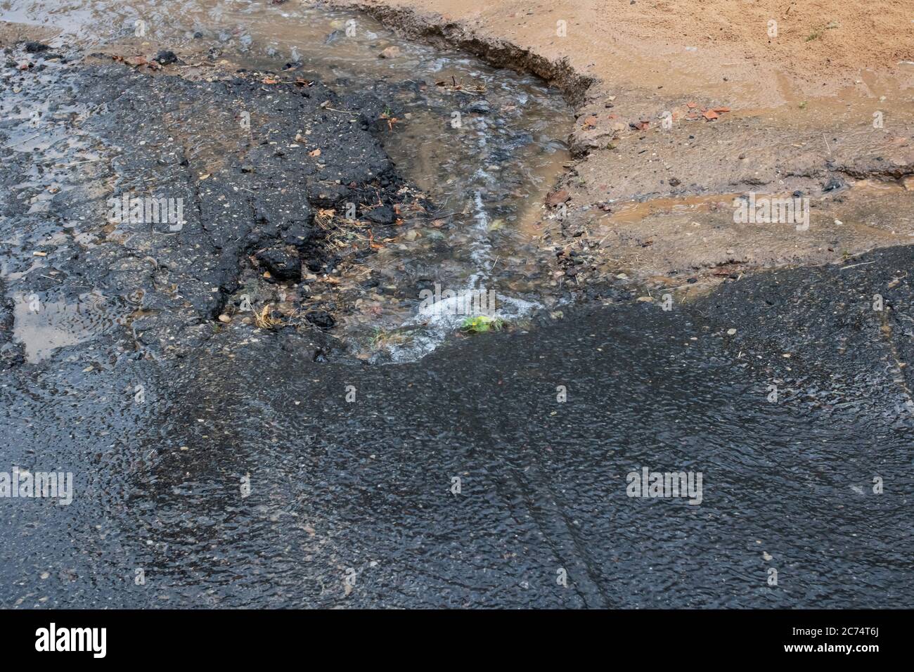 Water from rain flows along the road Stock Photo - Alamy
