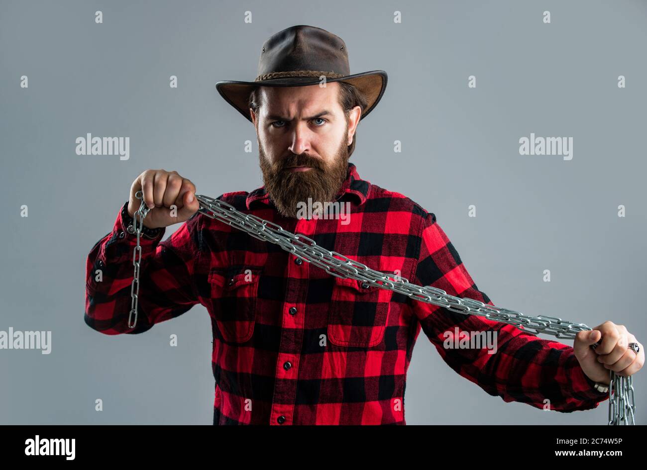 brutal man in cowboy hat with chain. chained up in chains. bearded man ...