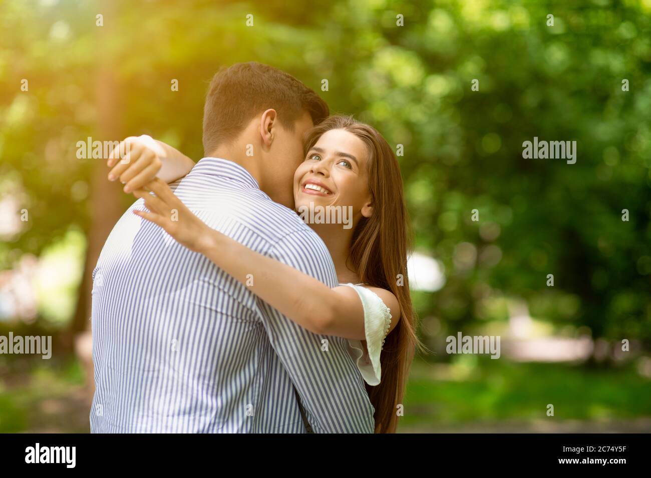 Happy young girl hugging her beloved boyfriend at park in summertime, copy space Stock Photo - Alamy