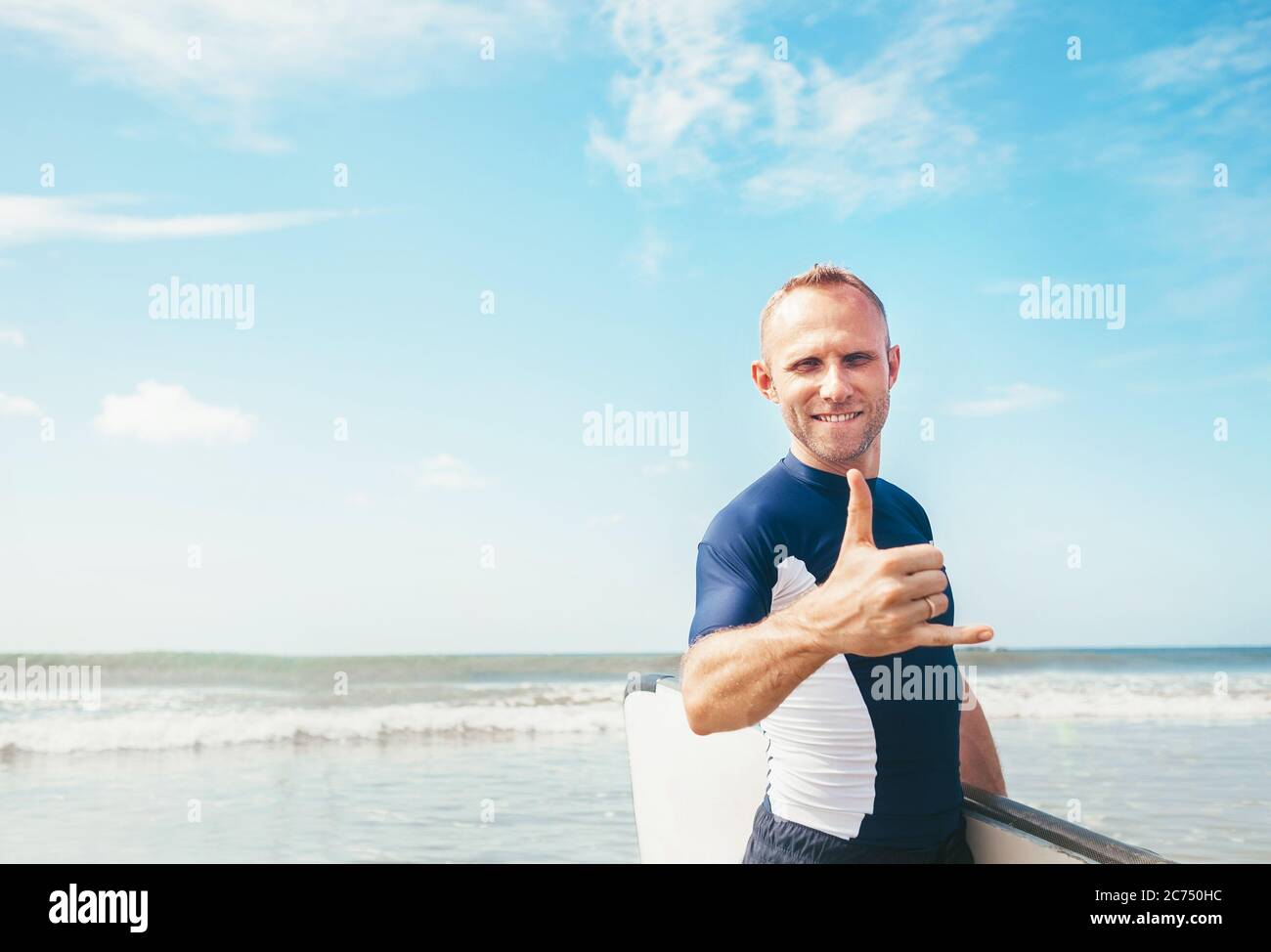 Young man Surfer portrait showing surfer's famous Shaka sign gesture in ...